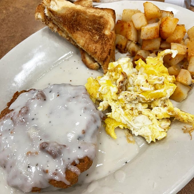 Chicken fried steak smothered in gravy alongside eggs and toast. Southern comfort on a plate that would make your cardiologist wince and your soul sing.