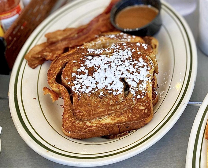 French toast that's achieved the impossible trifecta: golden-crisp exterior, custardy interior, and enough powdered sugar to make your dentist wince. Worth every calorie.