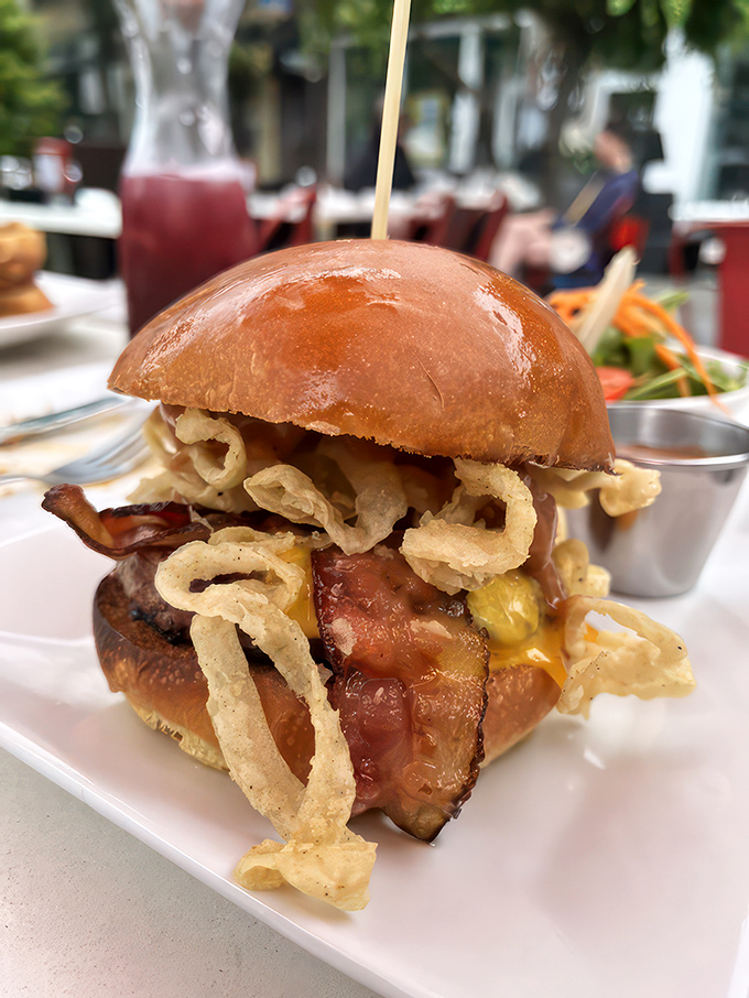 Holy cow is right! This burger's stacked higher than a Jenga tower. Grab some napkins and prepare for delicious defeat.