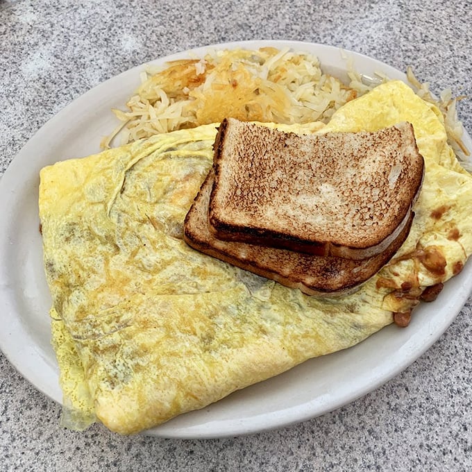This omelet isn't just breakfast, it's a golden, cheese-filled monument to morning indulgence.