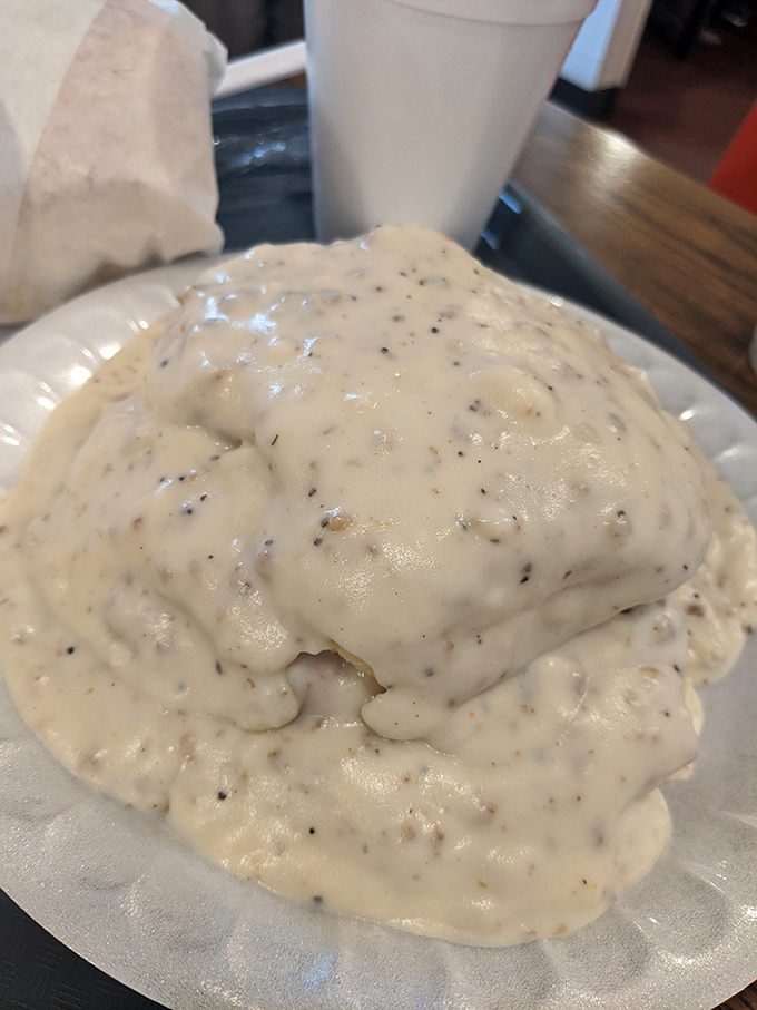 Gravy waterfall alert! This biscuit mountain is experiencing a delicious avalanche of sausage-studded gravy. Grab a fork and dive in!