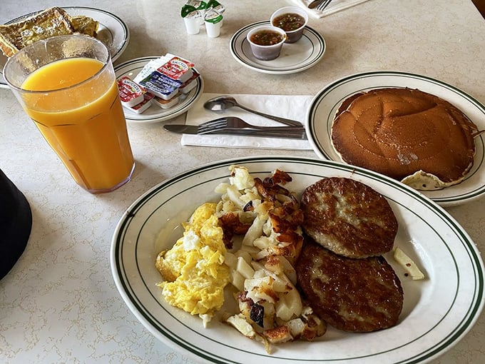 Behold the holy trinity of breakfast: perfectly scrambled eggs, golden hash browns, and sausage patties that would make your cardiologist wince but your soul sing.