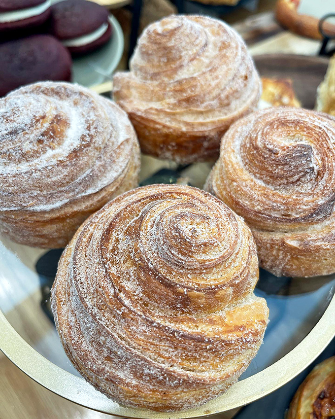 These aren't your average cinnamon buns - they're the Rolls Royce of pastries. Flaky, golden, and dusted with enough cinnamon to make your grandma jealous.