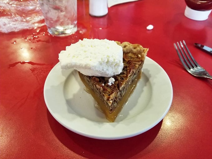 Pecan pie perfection! This slice is nuttier than a squirrel's winter stash, with a dollop of cream that's pure indulgence.