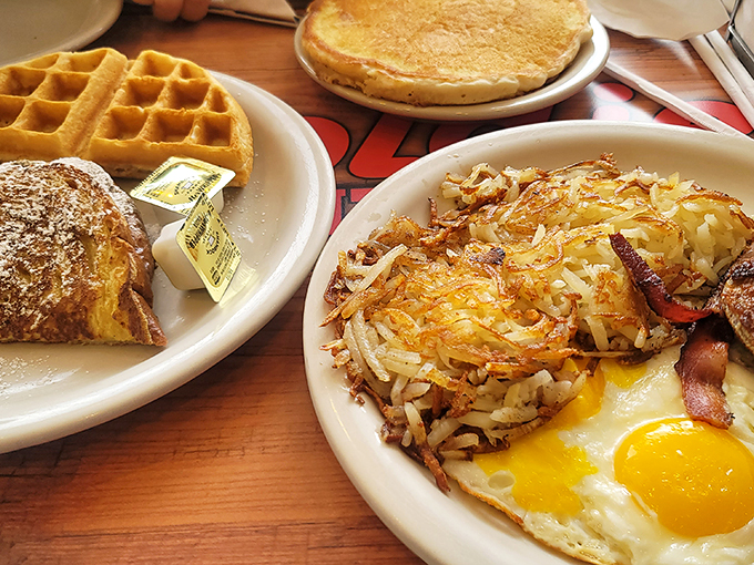 Golden waffles, crispy bacon, and fluffy eggs &ndash; oh my! This plate is the holy trinity of breakfast, blessed by the syrup gods themselves.