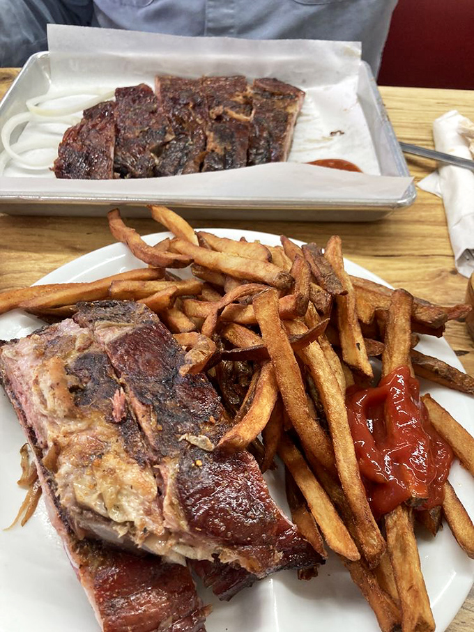 The kind of rib that makes you forget table manners exist. That perfect pink smoke ring is the barbecue equivalent of a Michelin star.