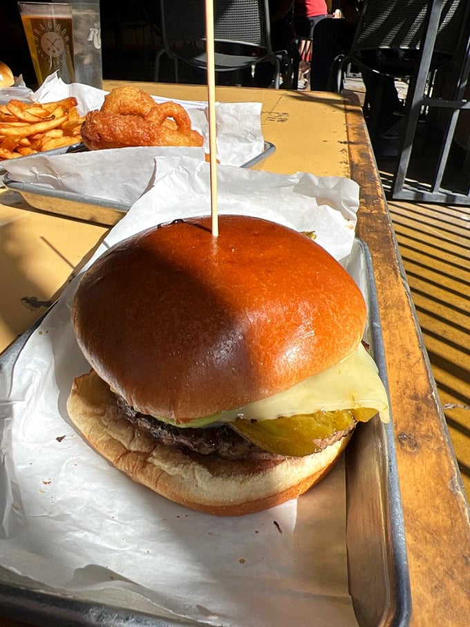 Holy guacamole! This burger's got more layers than a telenovela, topped with a perfectly ripe avocado slice that's ready for its close-up.