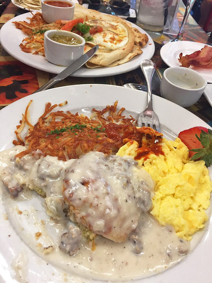Biscuits swimming in creamy country gravy alongside golden hashbrowns—the breakfast that makes you consider a mid-morning nap worth scheduling.