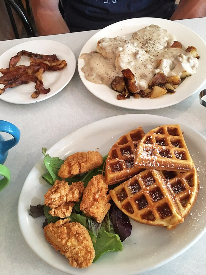 A breakfast trifecta that'd make Ron Swanson proud: golden waffles, crispy chicken, and biscuits swimming in a sea of creamy gravy.