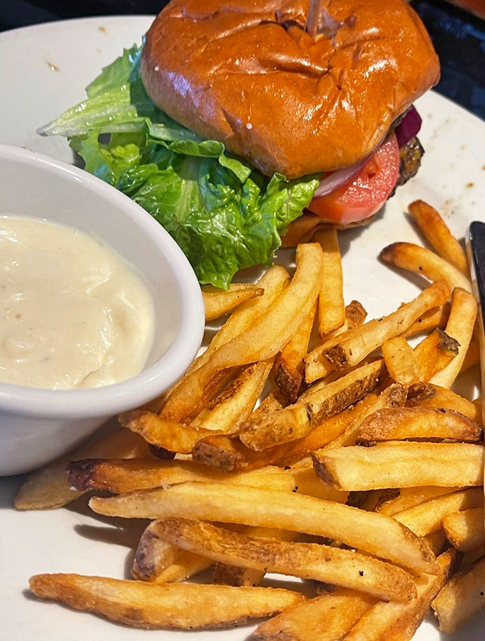 Burger alert! This isn't just a sandwich; it's a towering monument to beef, complete with a golden side of crispy potato perfection.