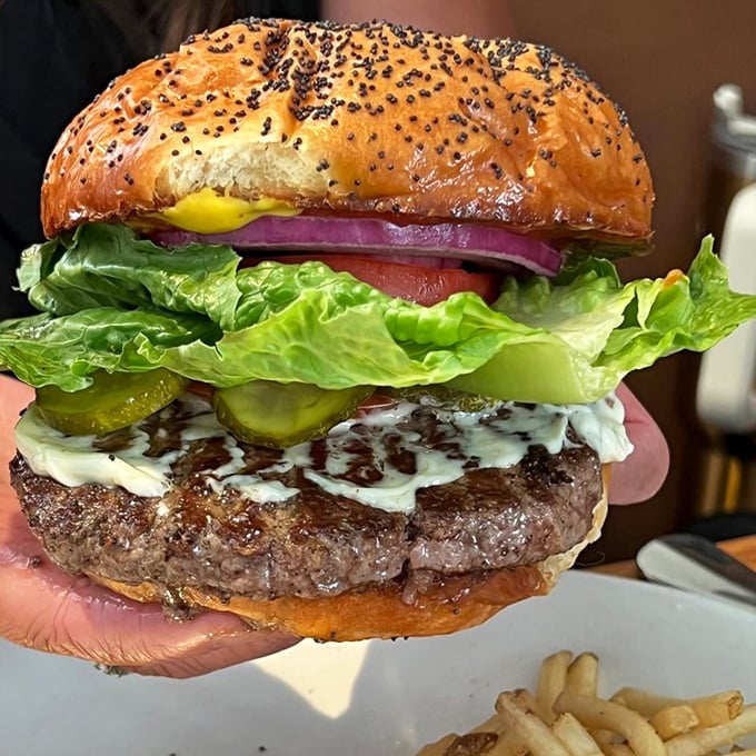Holy cow! This burger is so tall, it should come with its own stepladder. Prepare for a delicious balancing act of flavors and textures.