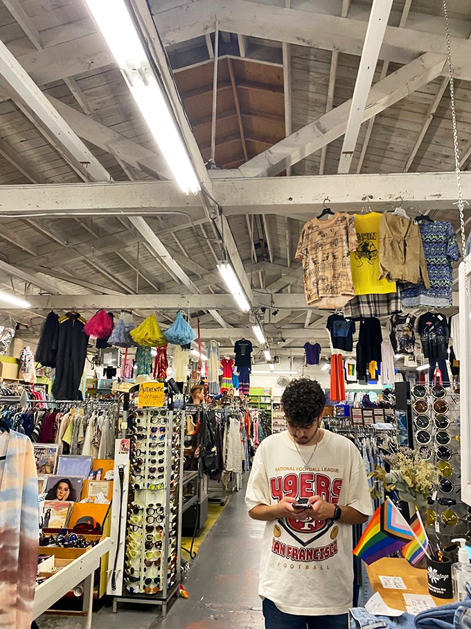 Treasure hunting in progress! The thrill of discovery is written all over this shopper's face as he examines a vintage 49ers tee.