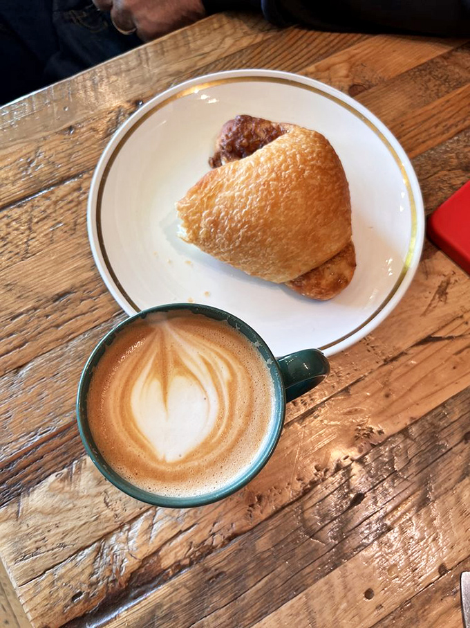 A perfectly crafted latte and golden croissant - proof that some of life's greatest pleasures come in pairs.