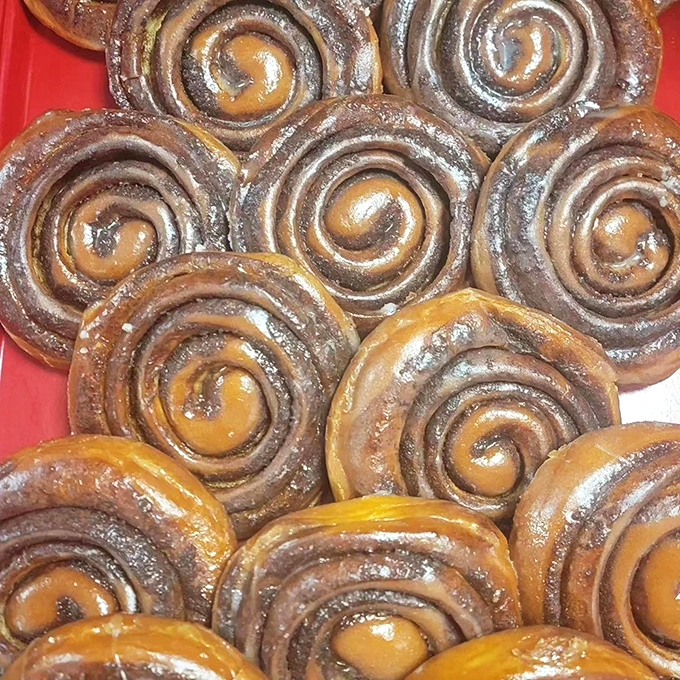 These cinnamon rolls aren't just spirals of dough; they're hypnotic vortexes of caramelized cinnamon and sugar that could make a pastry chef weep.