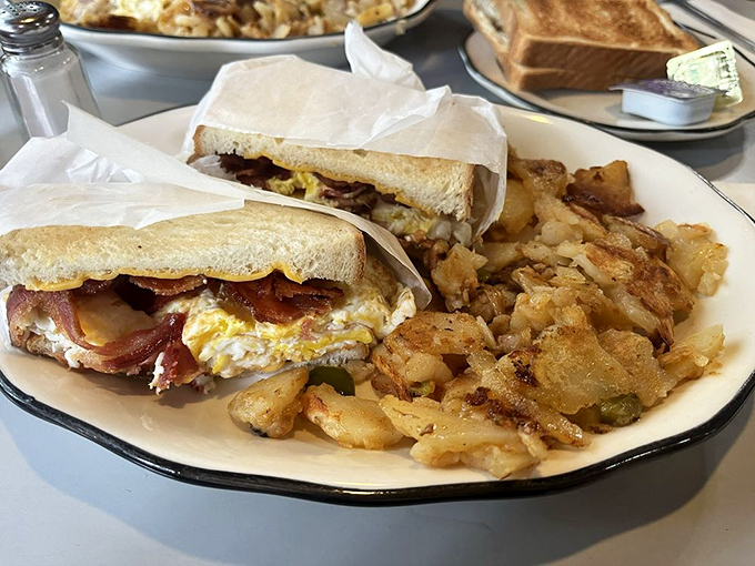 Sandwich perfection, wrapped and ready for action. This beauty, flanked by crispy potatoes, is the kind of meal that makes you wonder why you ever ate anything else.