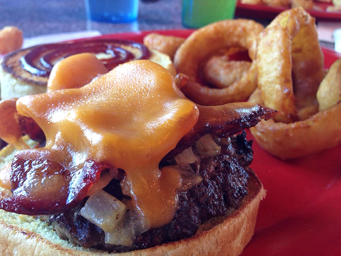 Cheese Louise! This burger is stacked higher than your grandpa's stories about walking to school uphill both ways. Napkins are not optional.
