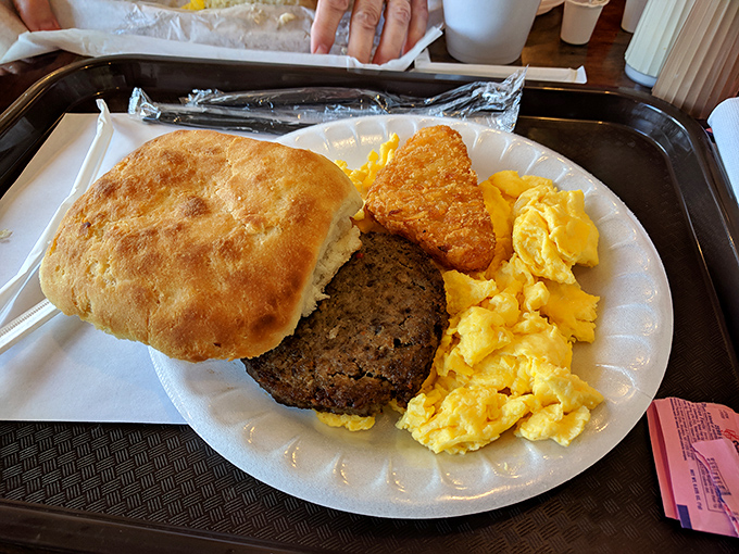 Breakfast of champions! This plate is a morning masterpiece &ndash; golden biscuit, savory sausage, and eggs sunny enough to brighten your day.