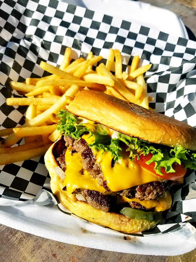 This isn't just a burger &ndash; it's architecture, engineering, and art all stacked between two buns with fries standing guard on the side.