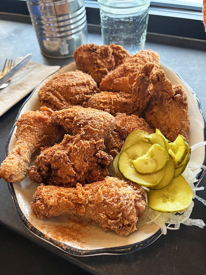 Fried chicken so perfectly golden it should come with its own security detail, served with pickles that add just the right counterpoint.