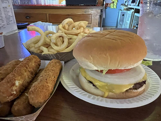The holy trinity of comfort food: a perfect cheeseburger, golden fries, and mozzarella sticks that stretch like your waistband will.