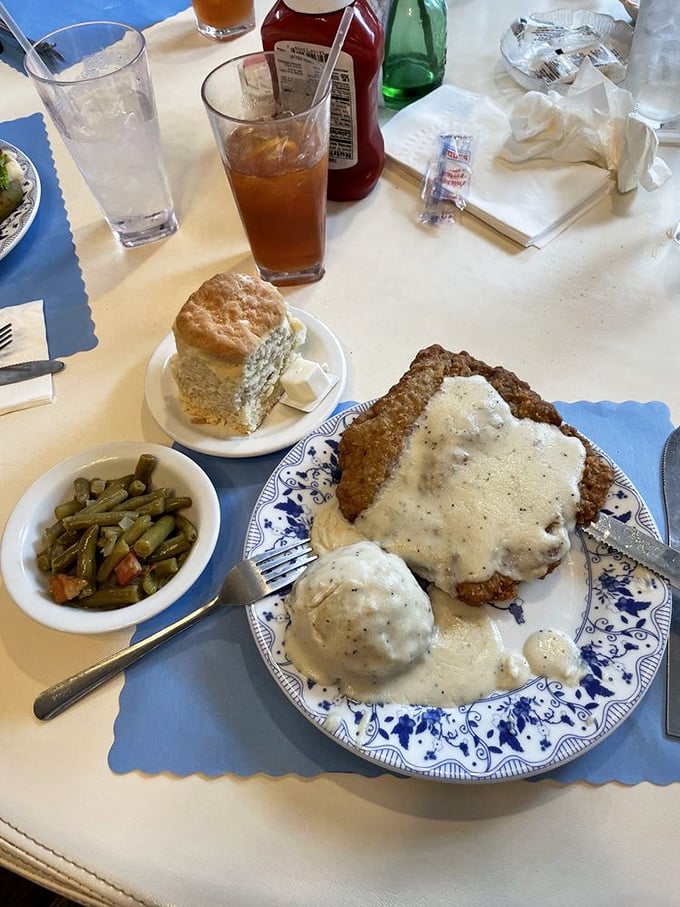 Country-fried steak smothered in gravy with a biscuit standing by. This plate doesn't just speak comfort&mdash;it gives you a full-body hug.