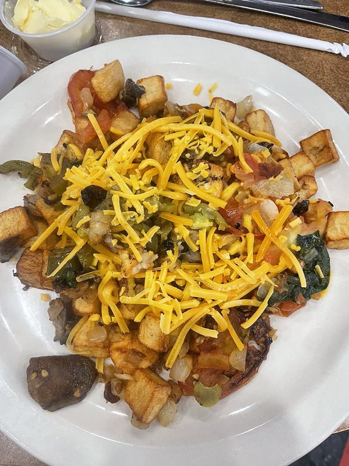 A mountain of potatoes, veggies, and cheese that laughs in the face of portion control. This tater bowl could fuel a marathon or a magnificent morning nap.