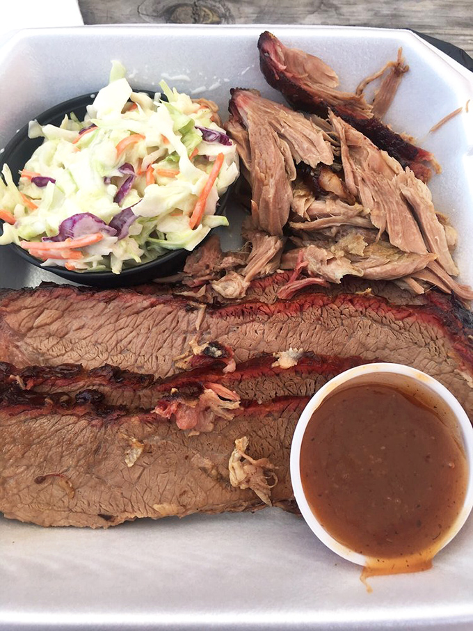 The holy trinity of barbecue: brisket with that pencil-thin smoke ring, pulled pork with perfect bark bits, and coleslaw that cuts through the richness.