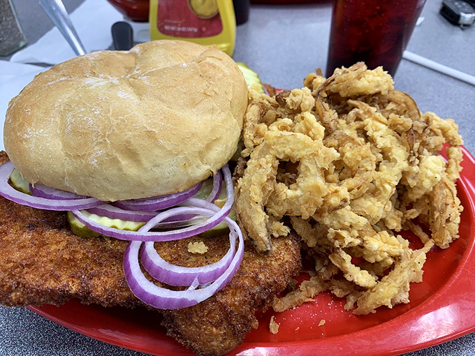 Holy schnitzels, Batman! This tenderloin's so big, it needs its own area code. Those onion rings? Crispy halos of happiness.