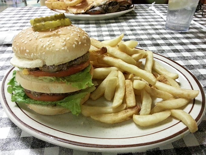 Holy cow! This burger's stacked higher than Elvis's pompadour. Better unhinge that jaw before taking a bite!