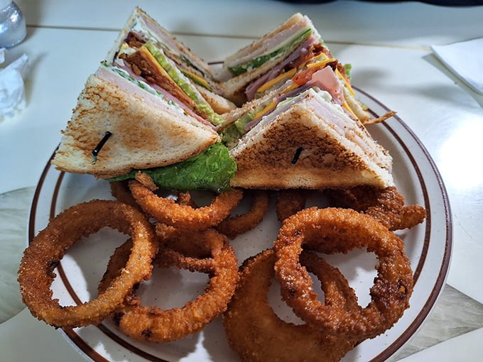 This club sandwich isn't playing around&mdash;stacked higher than your grandkid's college tuition and served with onion rings that demand respect.