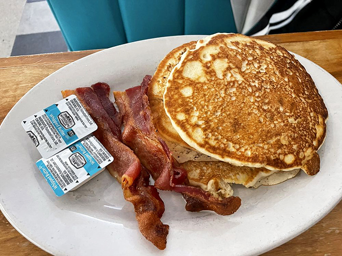 Pancakes, bacon, and enough syrup to swim in. This platter isn't just breakfast; it's a morning hug for your taste buds.