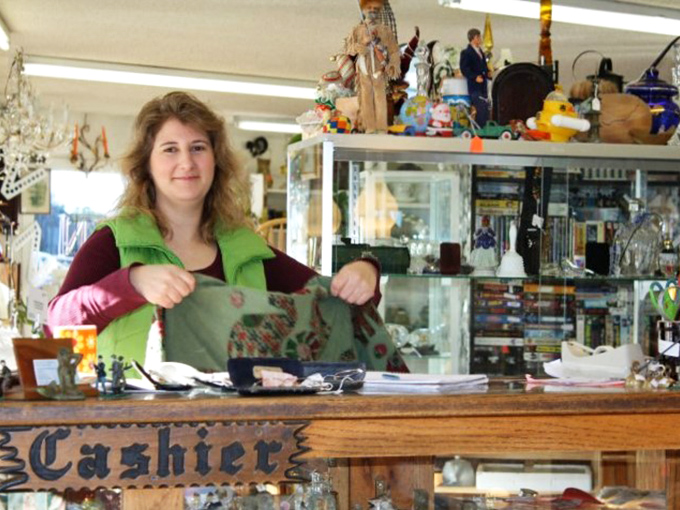 Meet the gatekeeper of gadgets and gizmos. Her warm smile invites you to explore the treasures behind the "Cashier" sign.