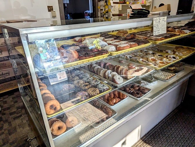 Donut heaven on earth! This display case is the stuff of sweet dreams, where every shelf tells a story of sugary perfection.