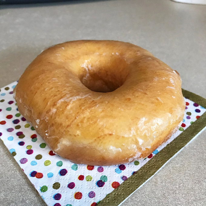 Simple perfection on a polka-dot napkin. This glazed doughnut is the little black dress of the pastry world &ndash; timeless, elegant, and always in style.