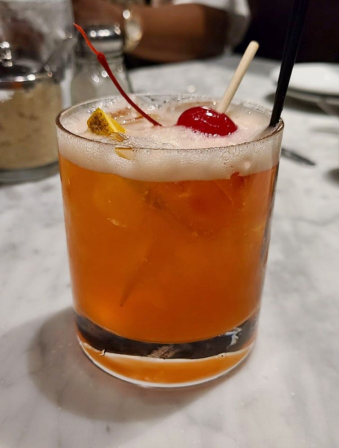 Cocktail hour just got an upgrade! This amber elixir, adorned with cherries, looks like it could turn even the most landlocked landlubber into a seasoned sailor.