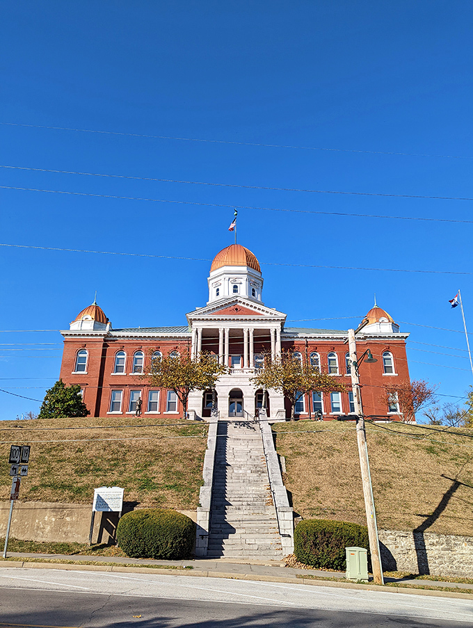 The Gasconade County Courthouse commands its hilltop like a brick-and-mortar monarch, its copper domes gleaming in the Missouri sun like royal crowns.