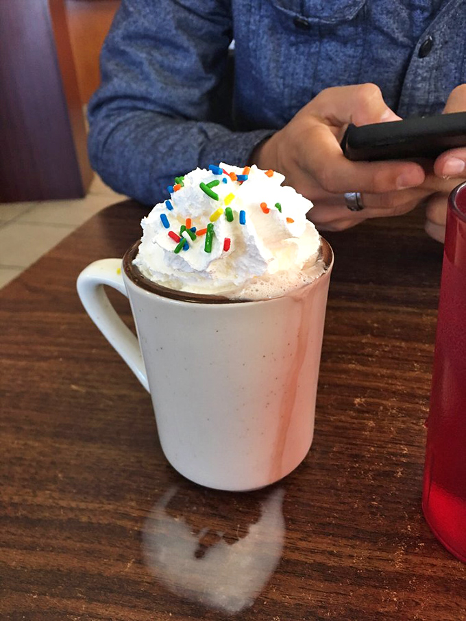 Hot chocolate that doesn't just arrive &ndash; it makes an entrance. Those rainbow sprinkles aren't childish; they're a celebration of life's simple pleasures.