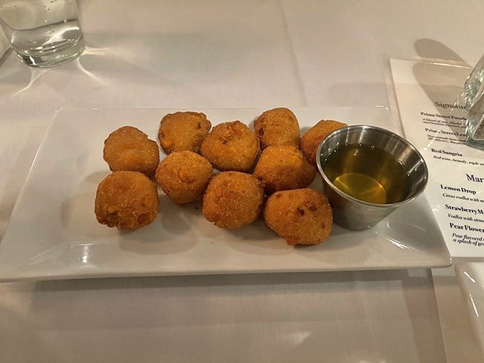 Golden hushpuppies that crunch like childhood memories, served with a honey butter that makes you question all other condiments.