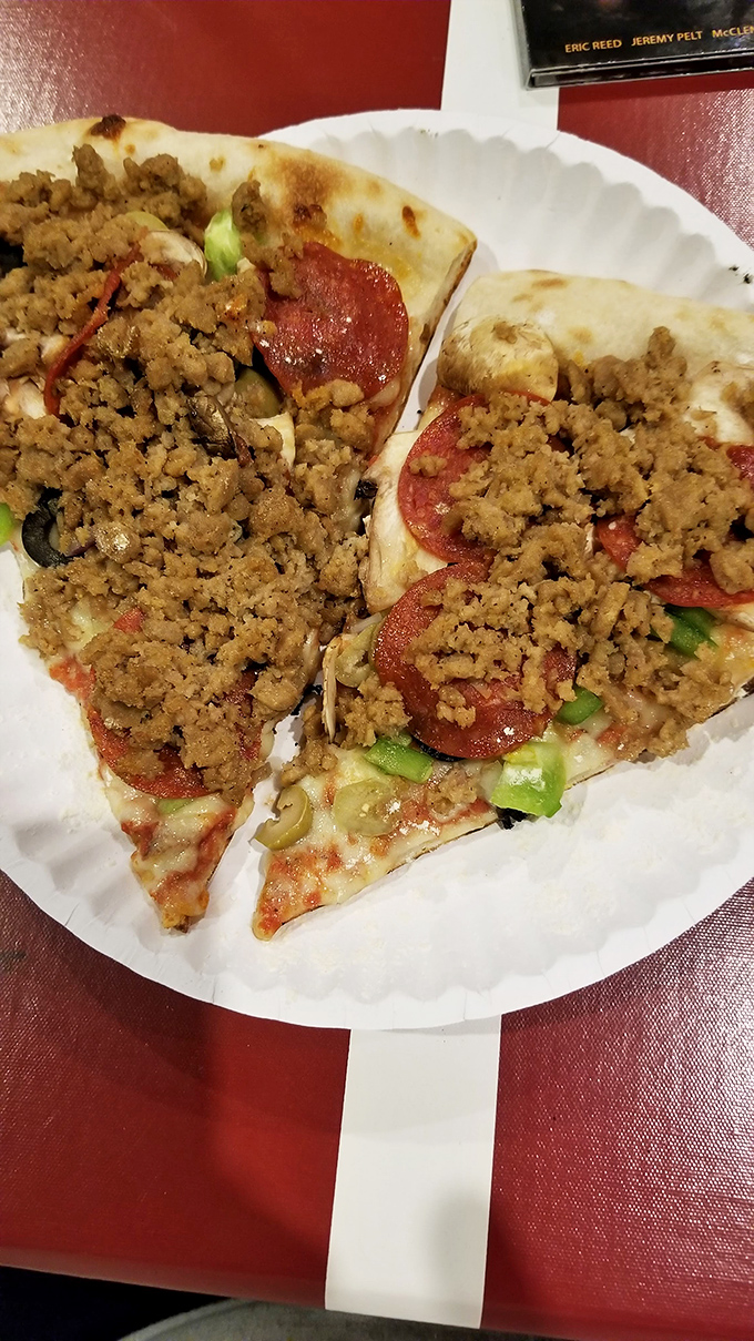 Holy toppings, Batman! This slice is a meat lover's dream, piled high with enough protein to make a bodybuilder blush.