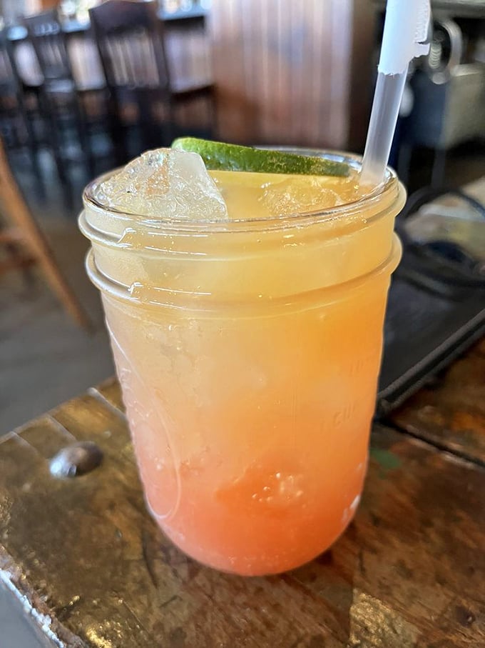 This isn't just a cocktail; it's sunshine in a mason jar, with that lime wedge practically winking at you with promises of tropical escape.