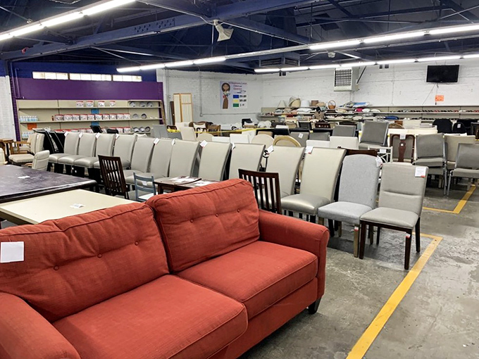 The red sofa beckons like an old friend while dining chairs stand at attention, ready to host your next dinner party without breaking the bank.