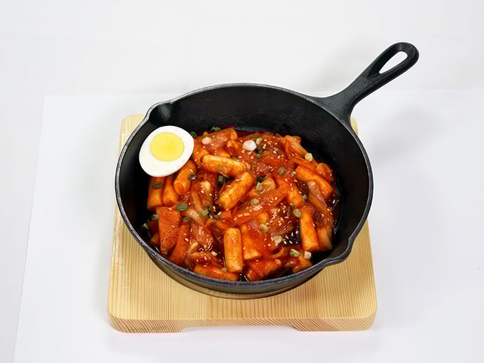 Tteok-bokki that demands attention! These chewy rice cakes swimming in spicy sauce with that perfect half-boiled egg are comfort food with a graduate degree.