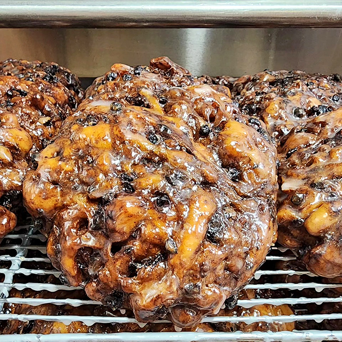Fresh apple fritters cooling on the rack&mdash;the donut equivalent of front-row concert tickets. Worth setting your alarm for 5 AM.