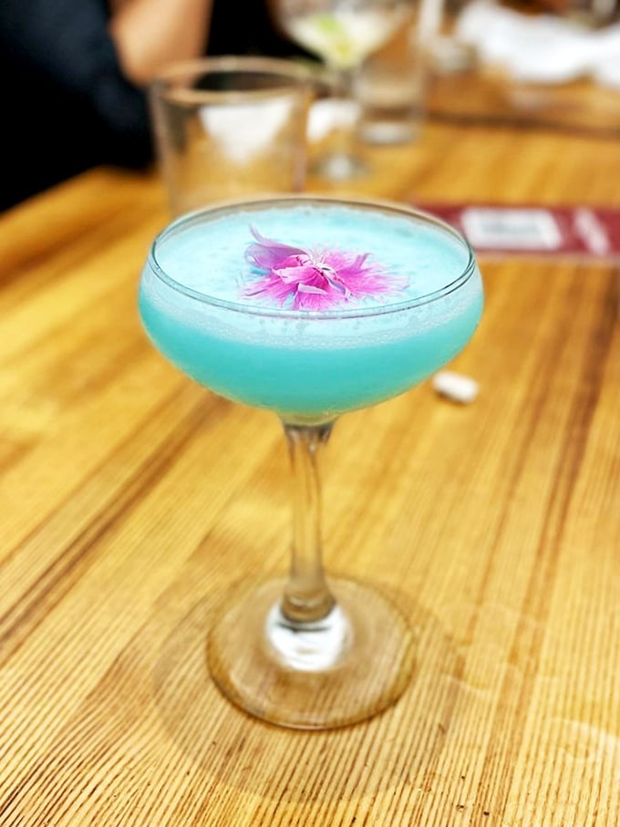 This electric blue cocktail with its delicate flower garnish screams "vacation mode activated" without a hint of tropical drink clich&eacute;.