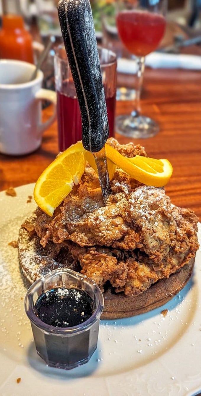 Fried chicken perched atop a waffle like a golden-brown crown, with maple syrup standing by for its royal duties.