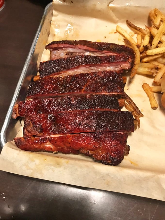 Ribs with a smoke ring so pronounced it could signal passing ships, alongside fries that crackle with each bite.