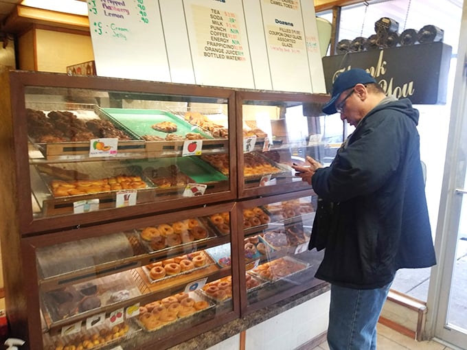 Decisions, decisions! This customer ponders life's greatest question: which donut will be the chosen one?