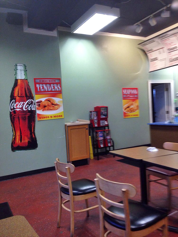 Simple wooden chairs and a Coca-Cola mural that says, "We're here for the food conversation, not the fancy furniture discussion."