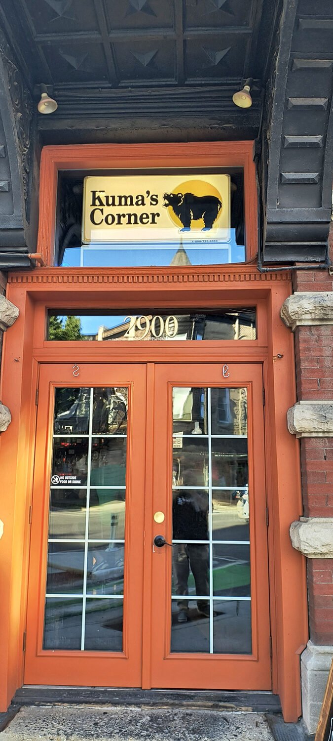 The gates to burger heaven! Kuma's entrance beckons with its warm orange glow and promise of meaty delights within.