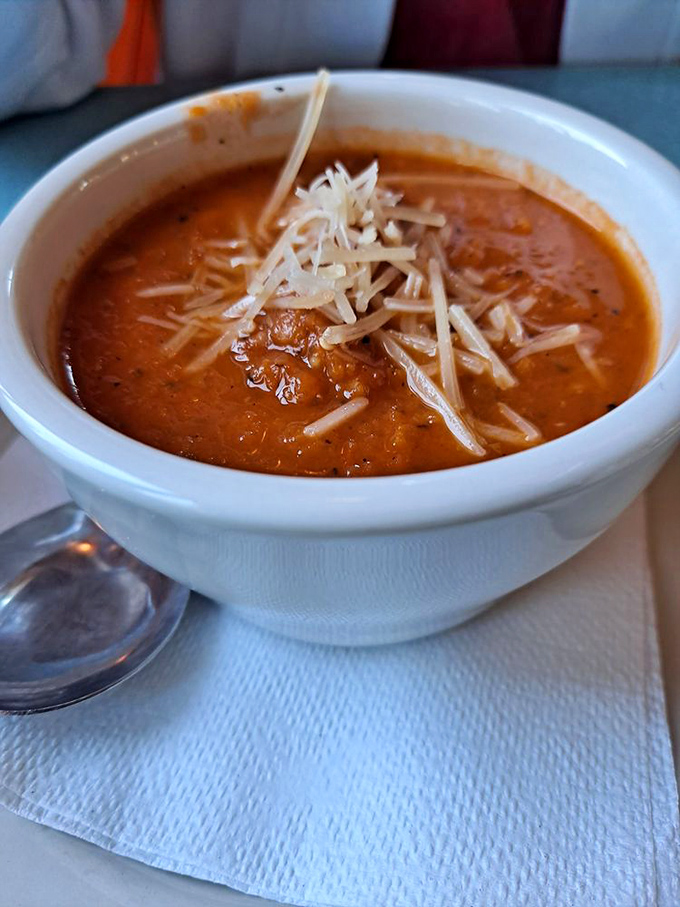Tomato bisque that's silkier than a lounge singer's voice, topped with cheese that melts like your resolve to eat sensibly.